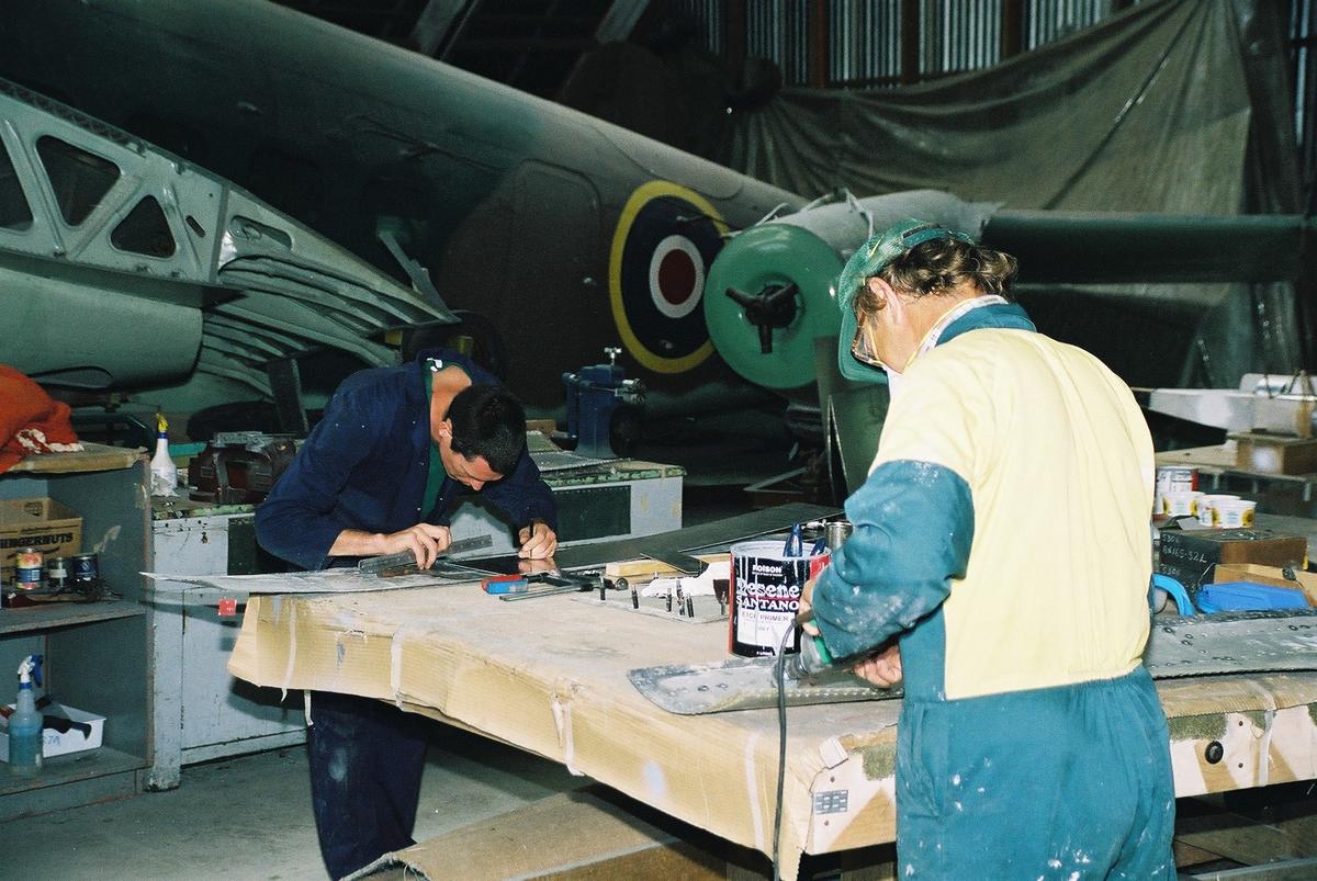[Two men at workbench in the blister hangar aviation workshop] - Museum ...