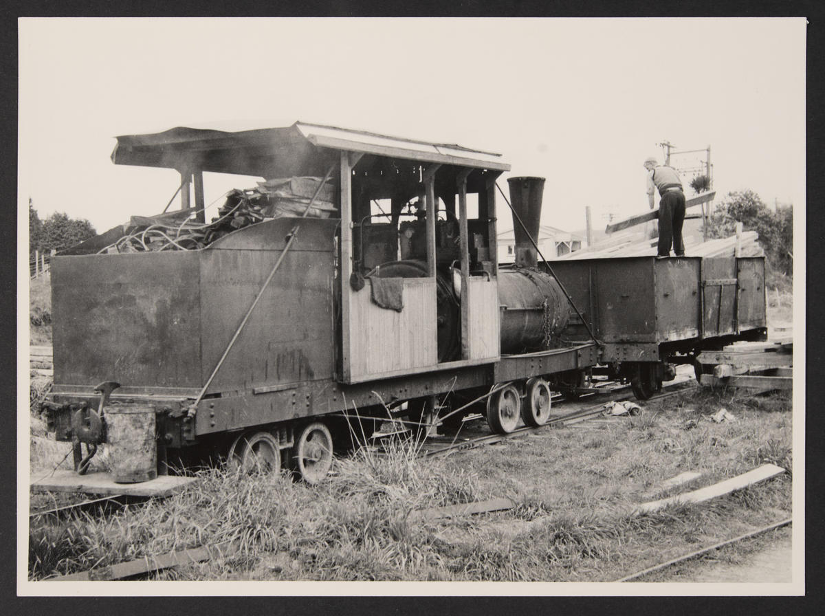 Bush tram locomotive resting on rails as a man in an attached wagon ...